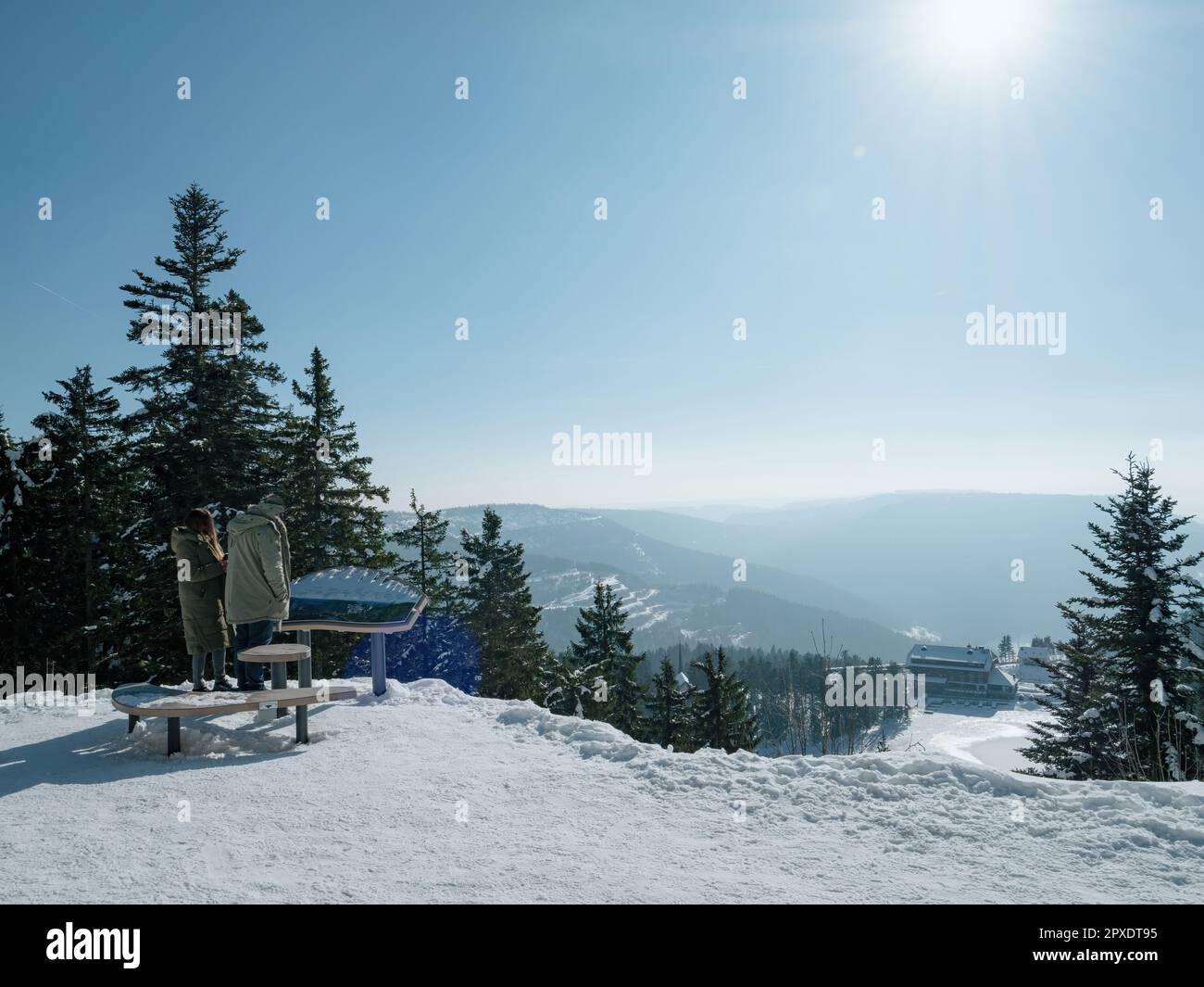 Two people admiring a tranquil winter landscape of Black Forest ...