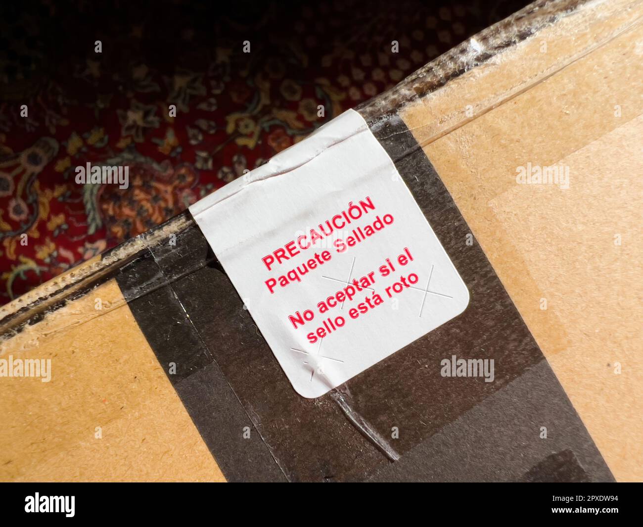 A tightly sealed brown package with a bright sign reading Take care ...