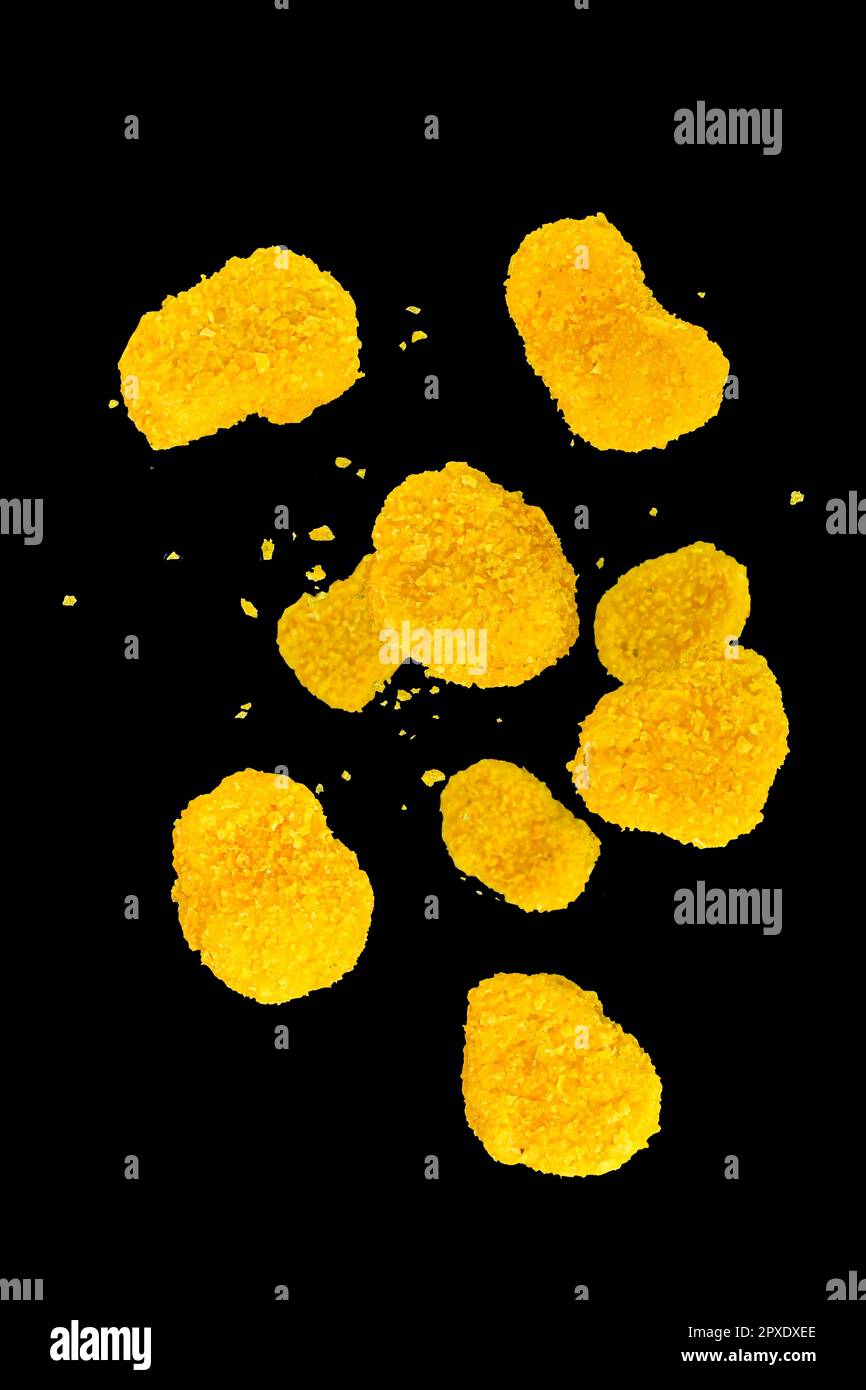 Falling nuggets isolated on a black background, selective focus. Fresh ...