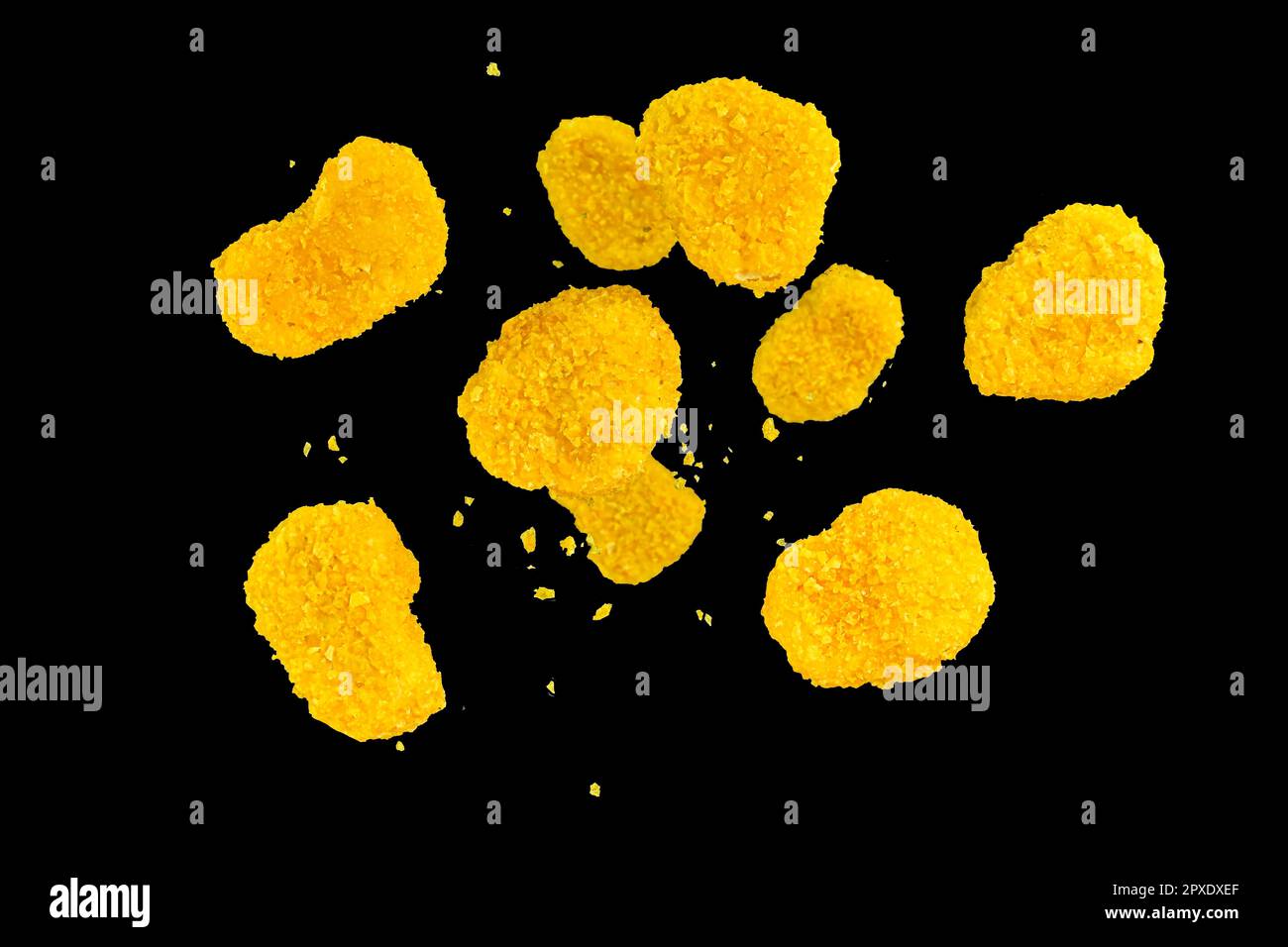 Fresh chicken nuggets falling on black background. Freeze motion of ...