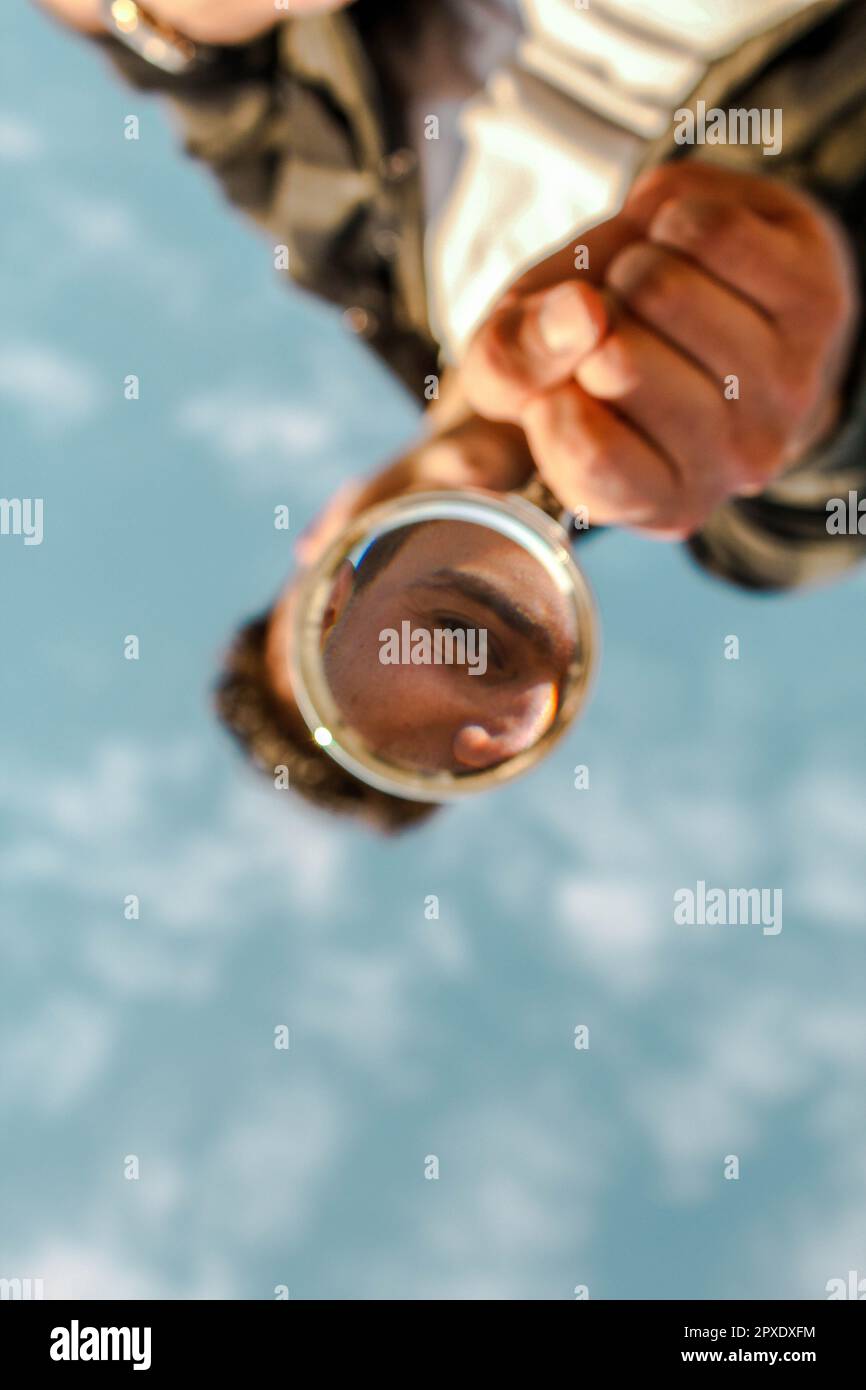 Man looking through the magnifying glass in the camera with the focus ...