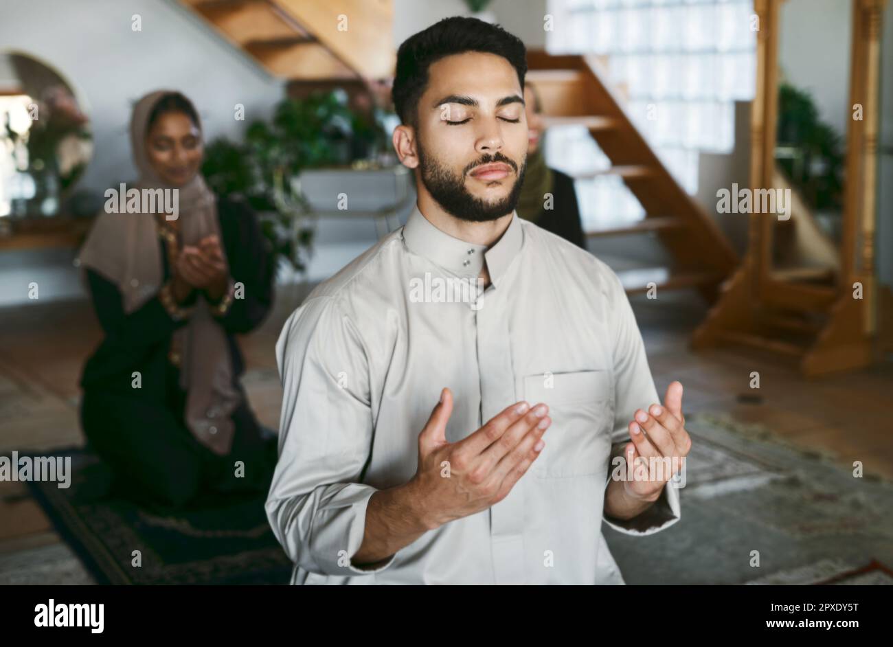 Be peaceful. a young muslim couple praying in the lounge at home Stock ...