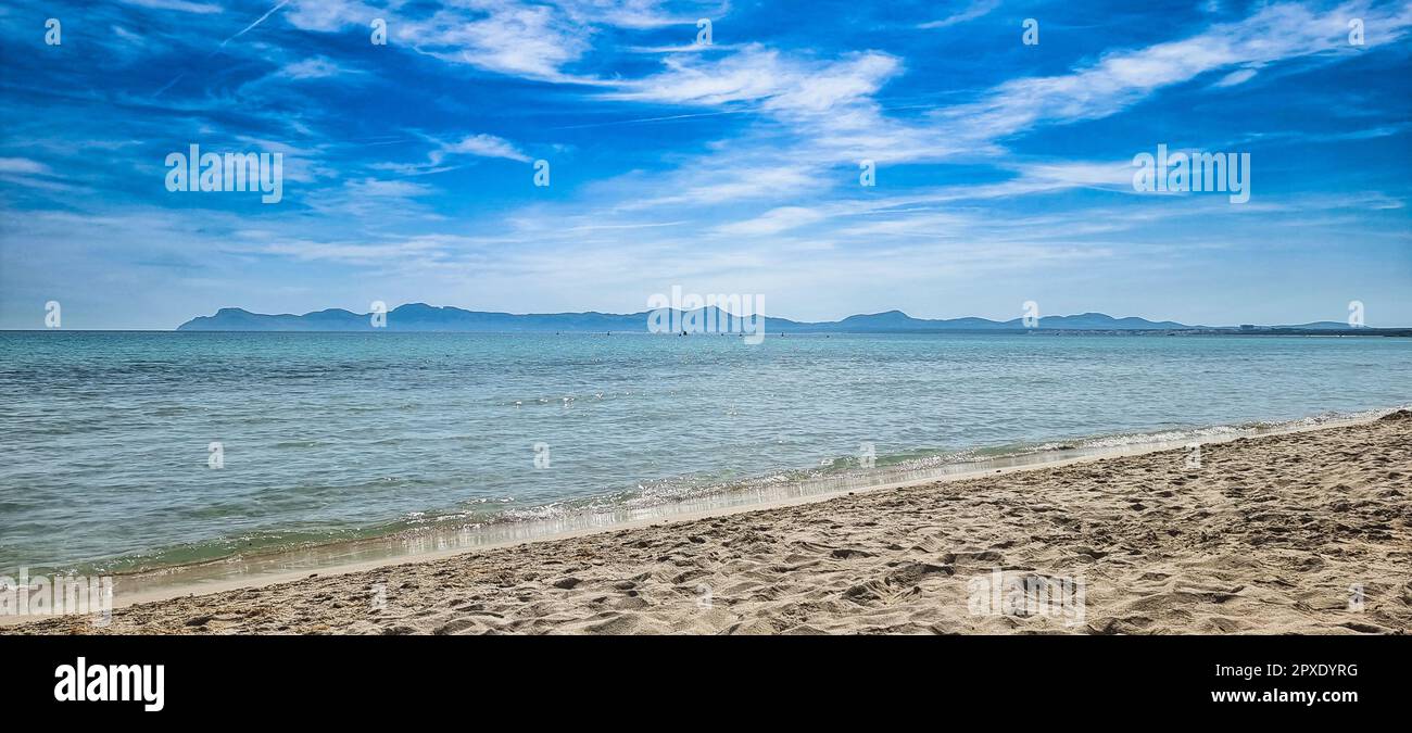 A scenic landscape of a tranquil open body of water with white clouds ...