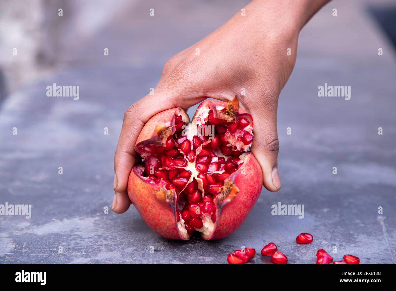 Hand holding pomegranate hi-res stock photography and images - Alamy