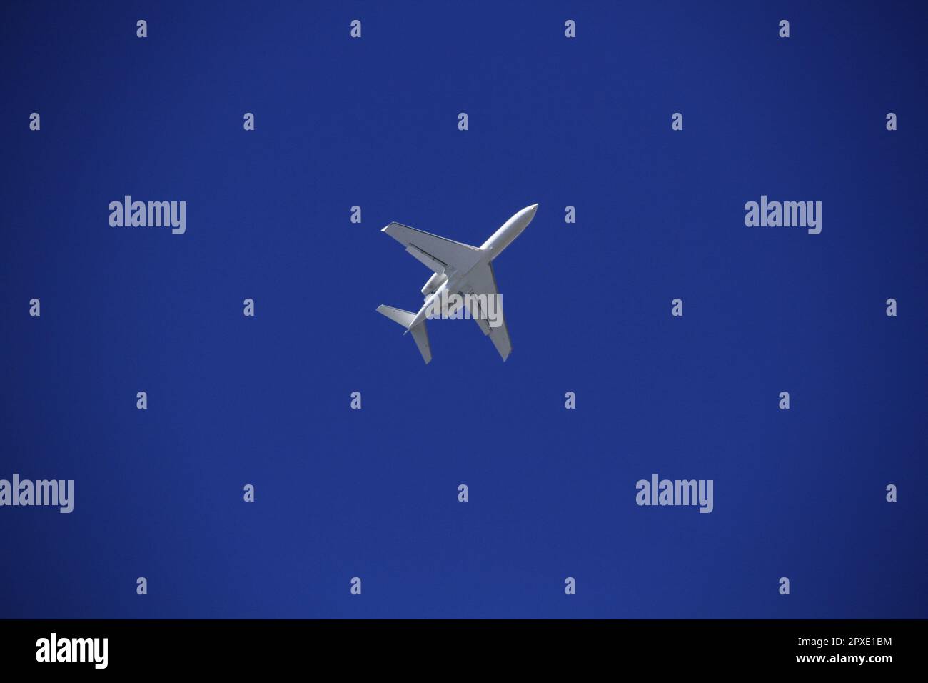 The plane crosses a very blue and clean sky, photographed from below ...