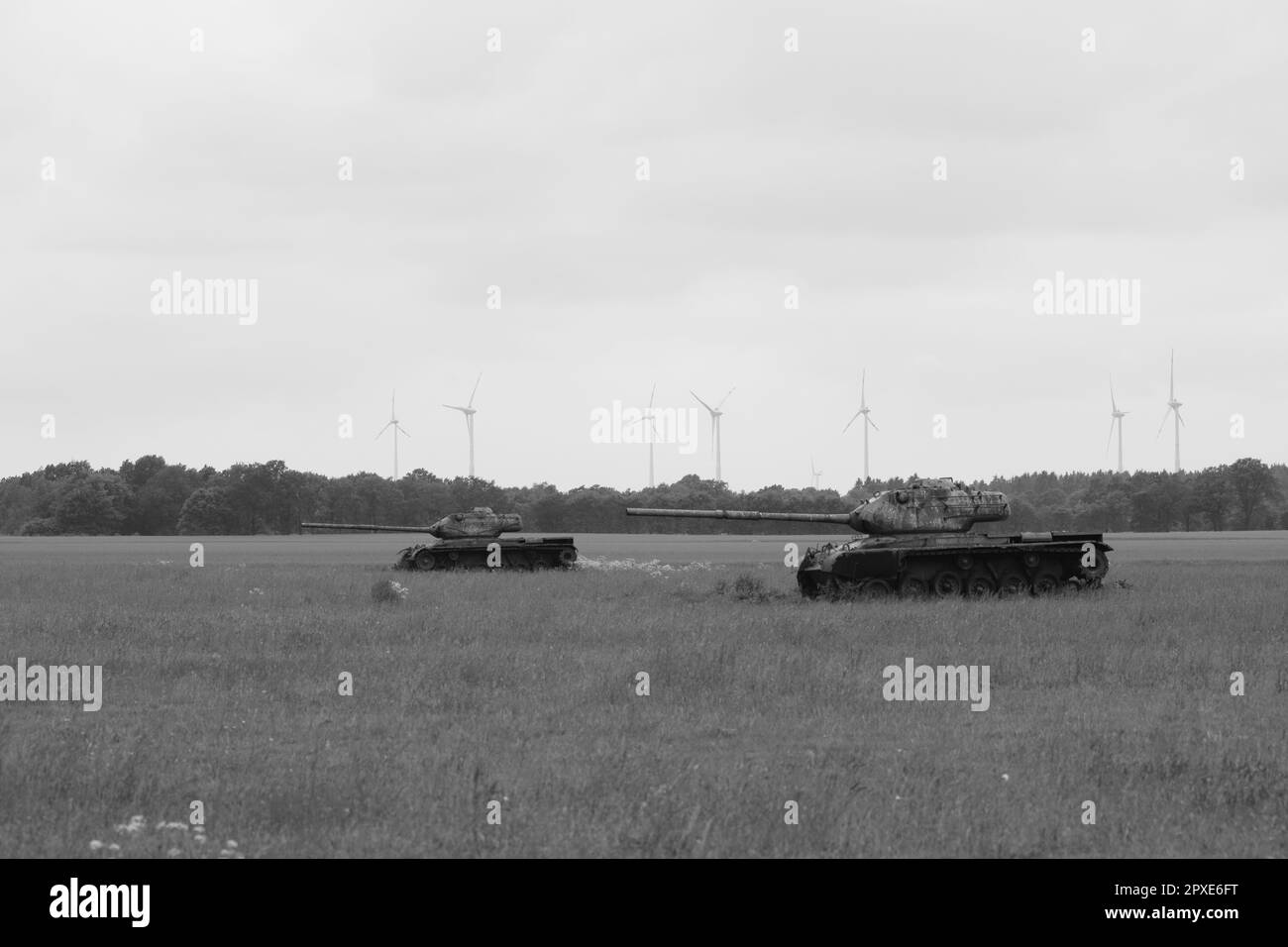 A grayscale shot of a tank situated in the center of a battlefield ...