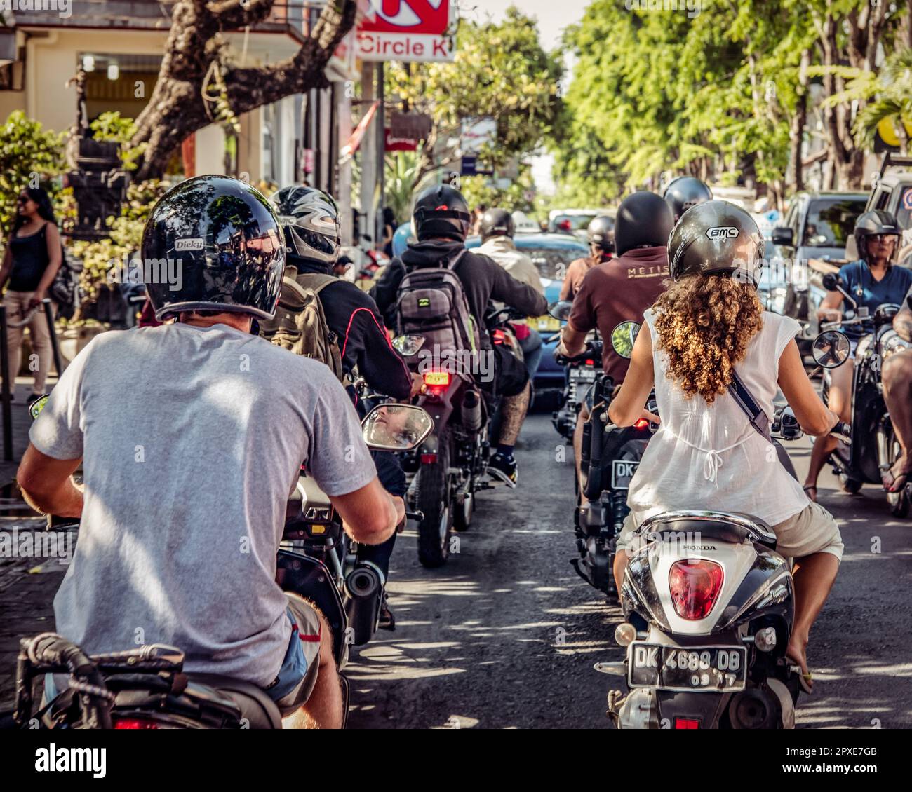 A back view of a group of motorcyclists on a road in Kuta, Indonesia ...