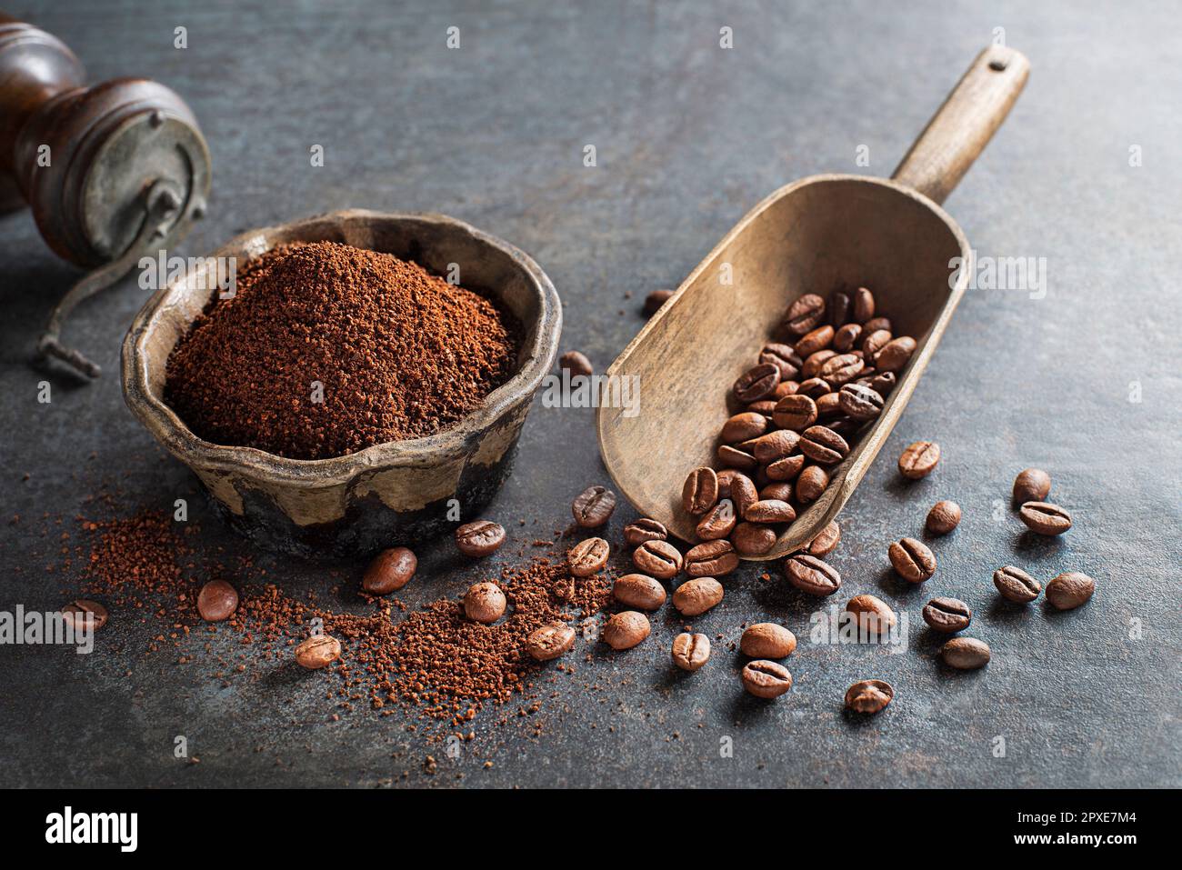 Coffee beans and freshly ground coffee powder on grey stone background ...