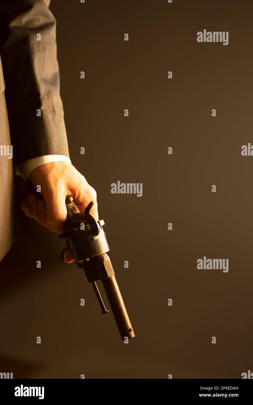 Male detective spy killer holding pistol gun in dramatic novel book ...