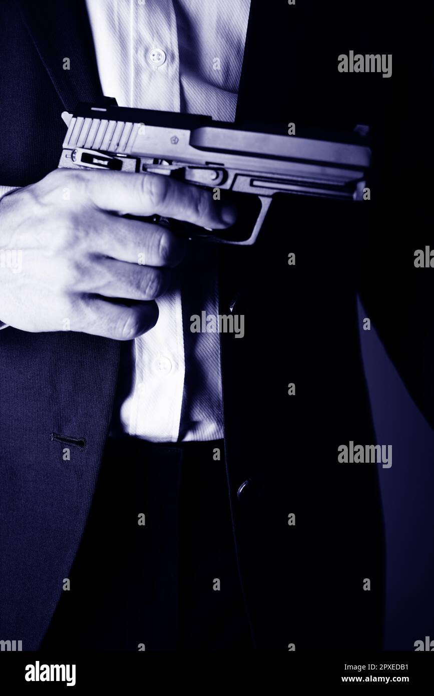 Retro secret agent with pistol revolver gun in hand in vintage crime ...