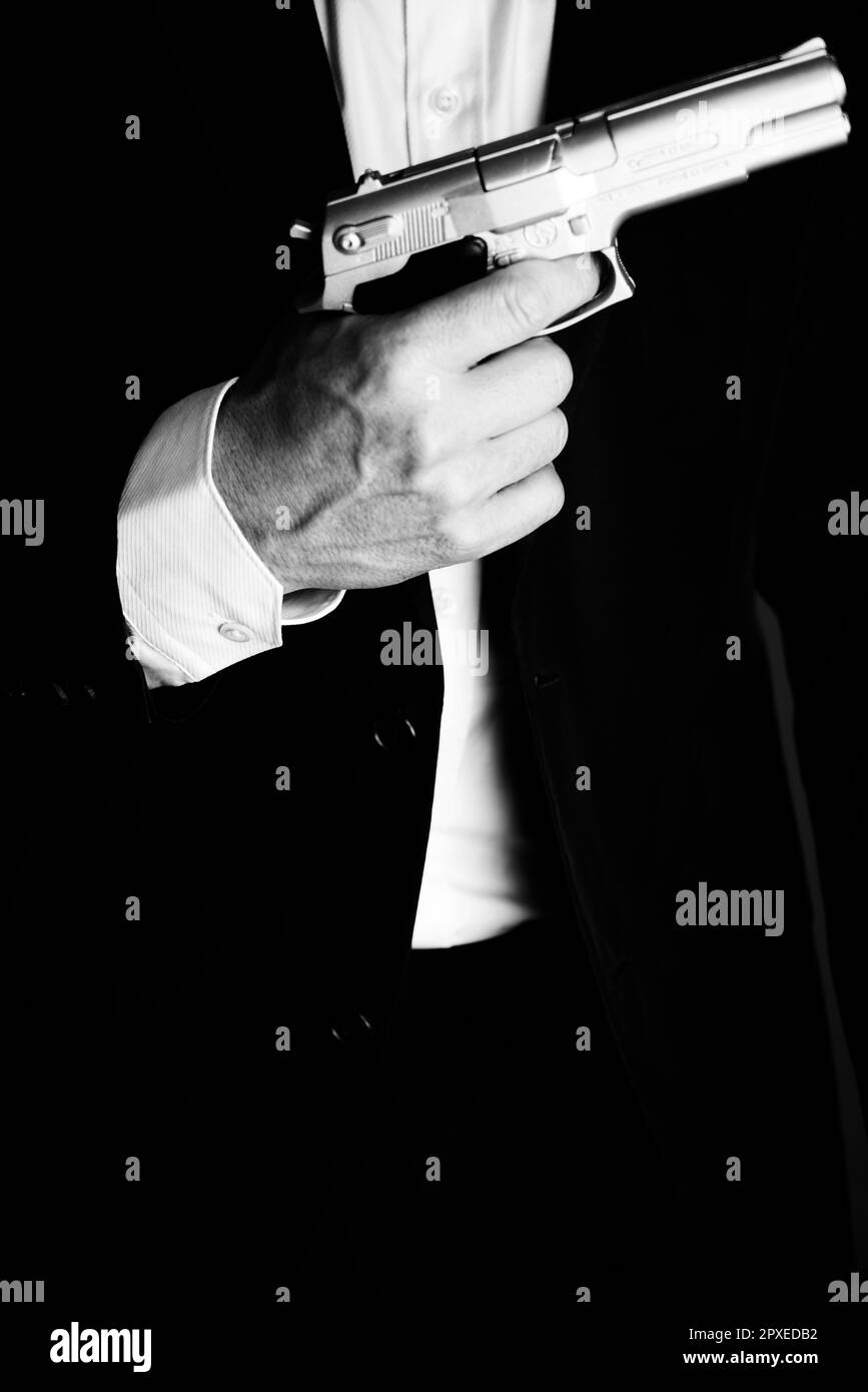 Retro secret agent with pistol revolver gun in hand in vintage crime ...