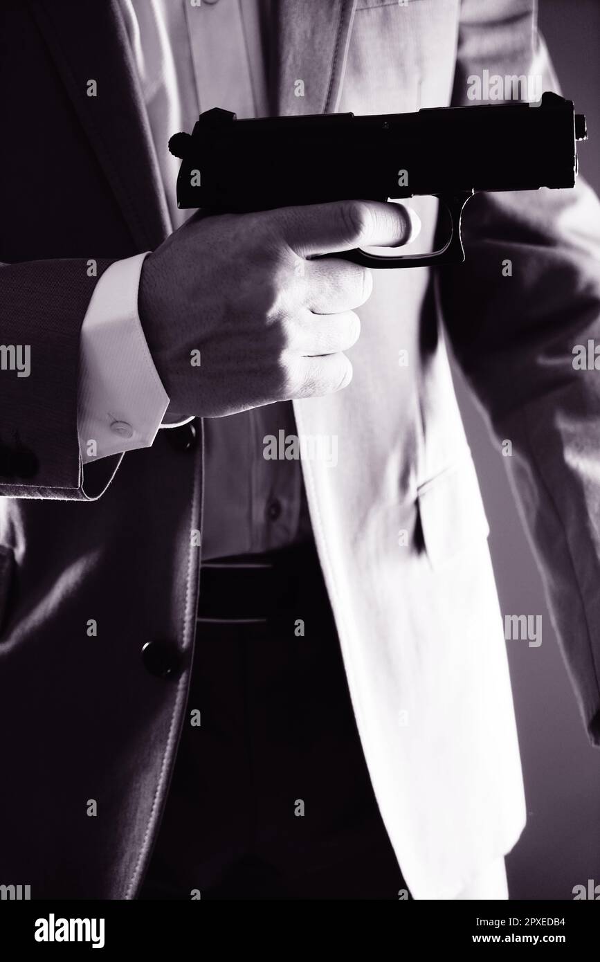 Retro secret agent with pistol revolver gun in hand in vintage crime ...