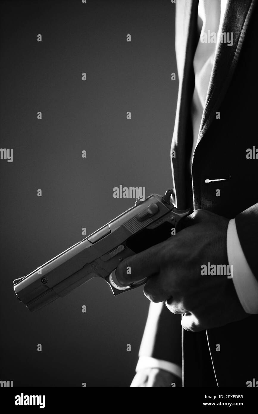 Retro secret agent with pistol revolver gun in hand in vintage crime ...