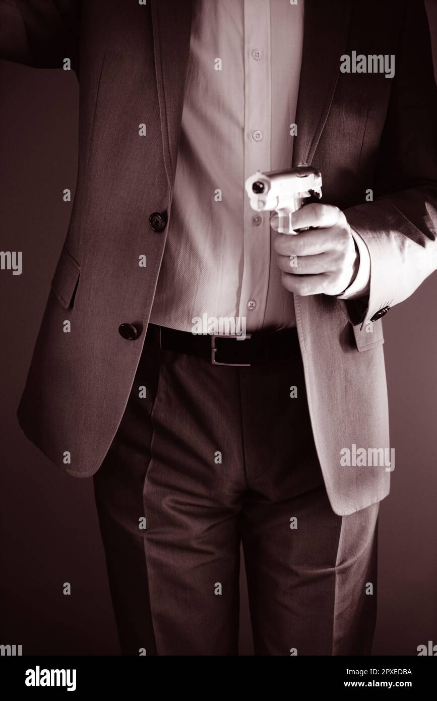 Retro secret agent with pistol revolver gun in hand in vintage crime ...