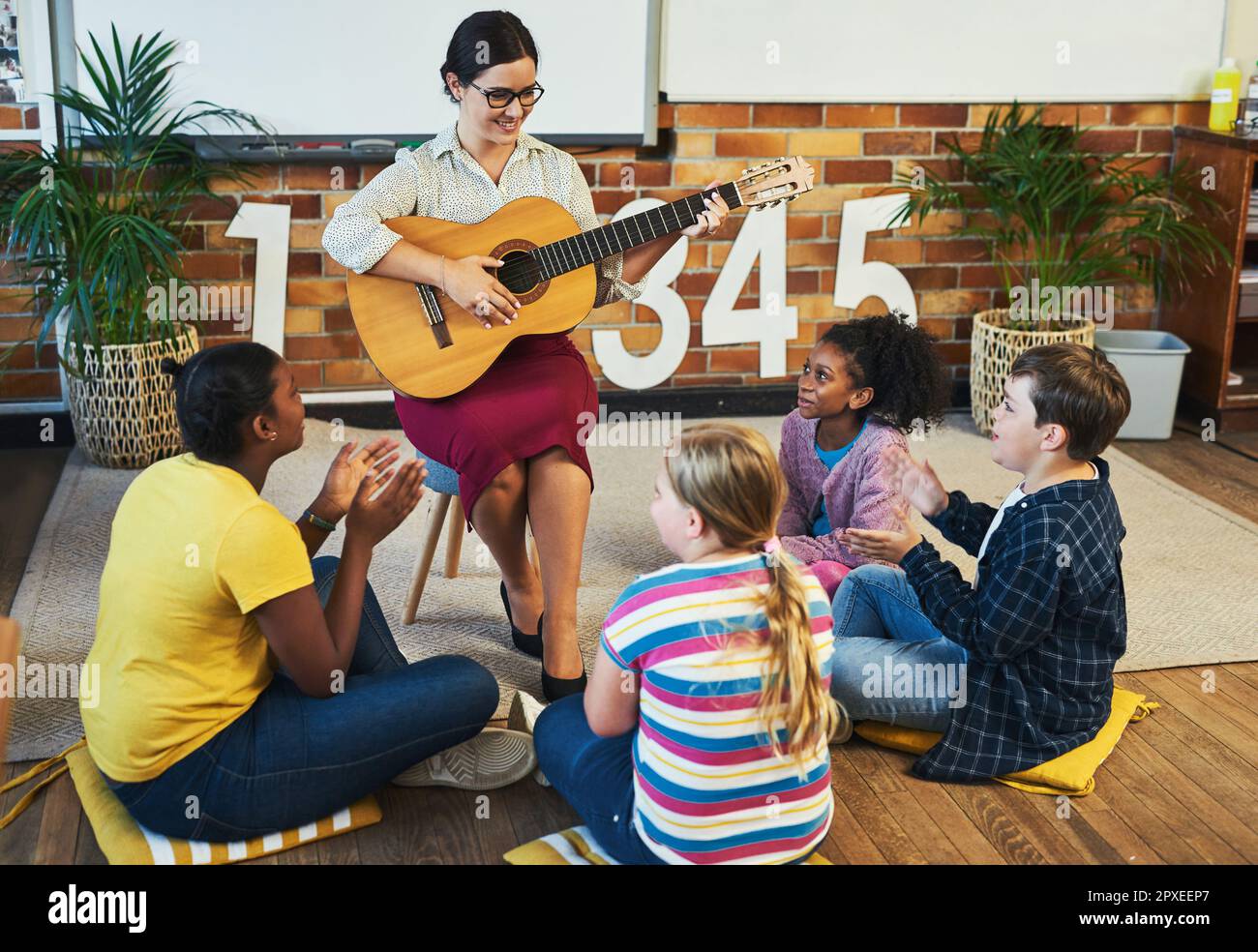 Is everyone ready for a song. Full length shot of a young teacher ...