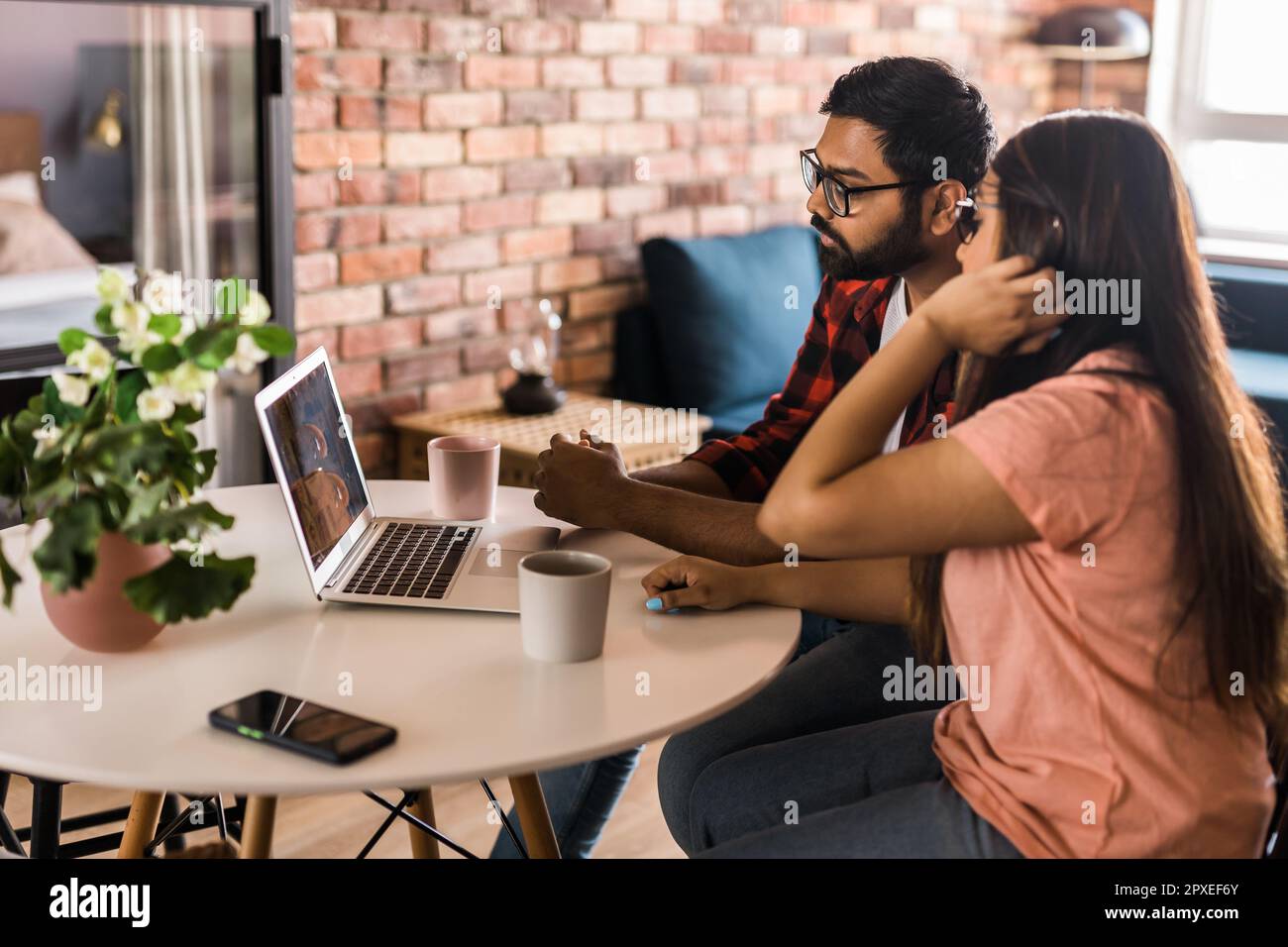 Happy indian family couple cuddle at desk make video call to friends ...