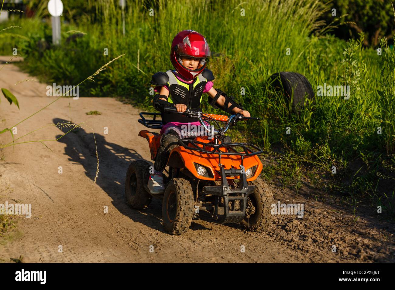 A child rides a quad bike through the mud. ATV rider rides Stock Photo ...