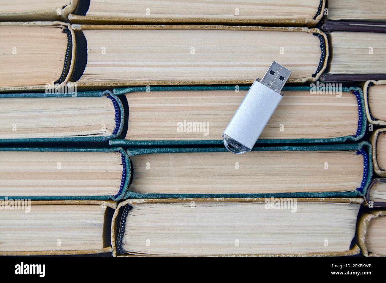 Computer usb drive on the background of a stack of old paper books ...