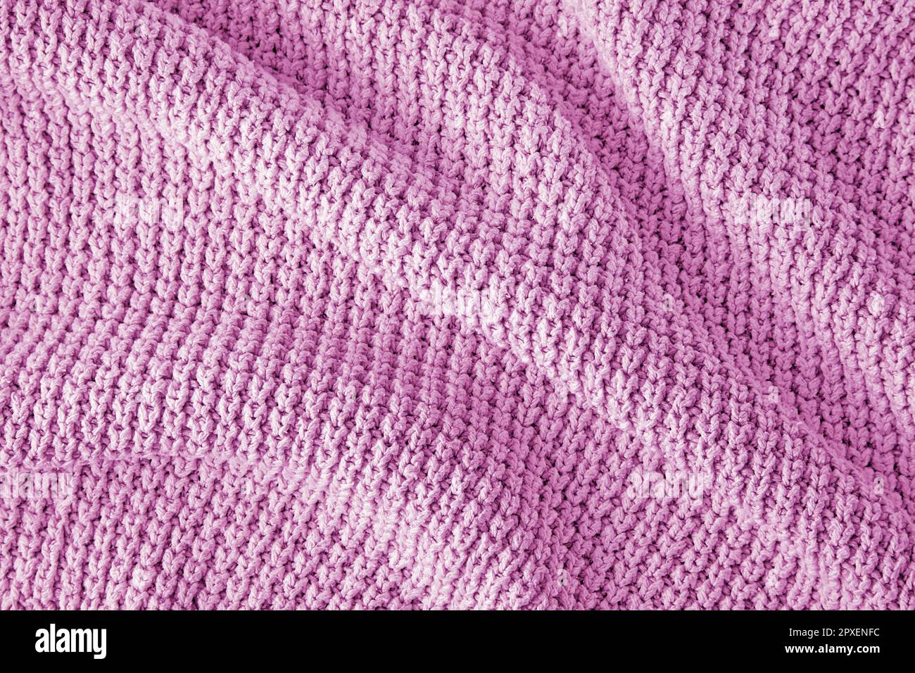 Pink knitted clothes in coarse knit with pleats and shadows as a ...