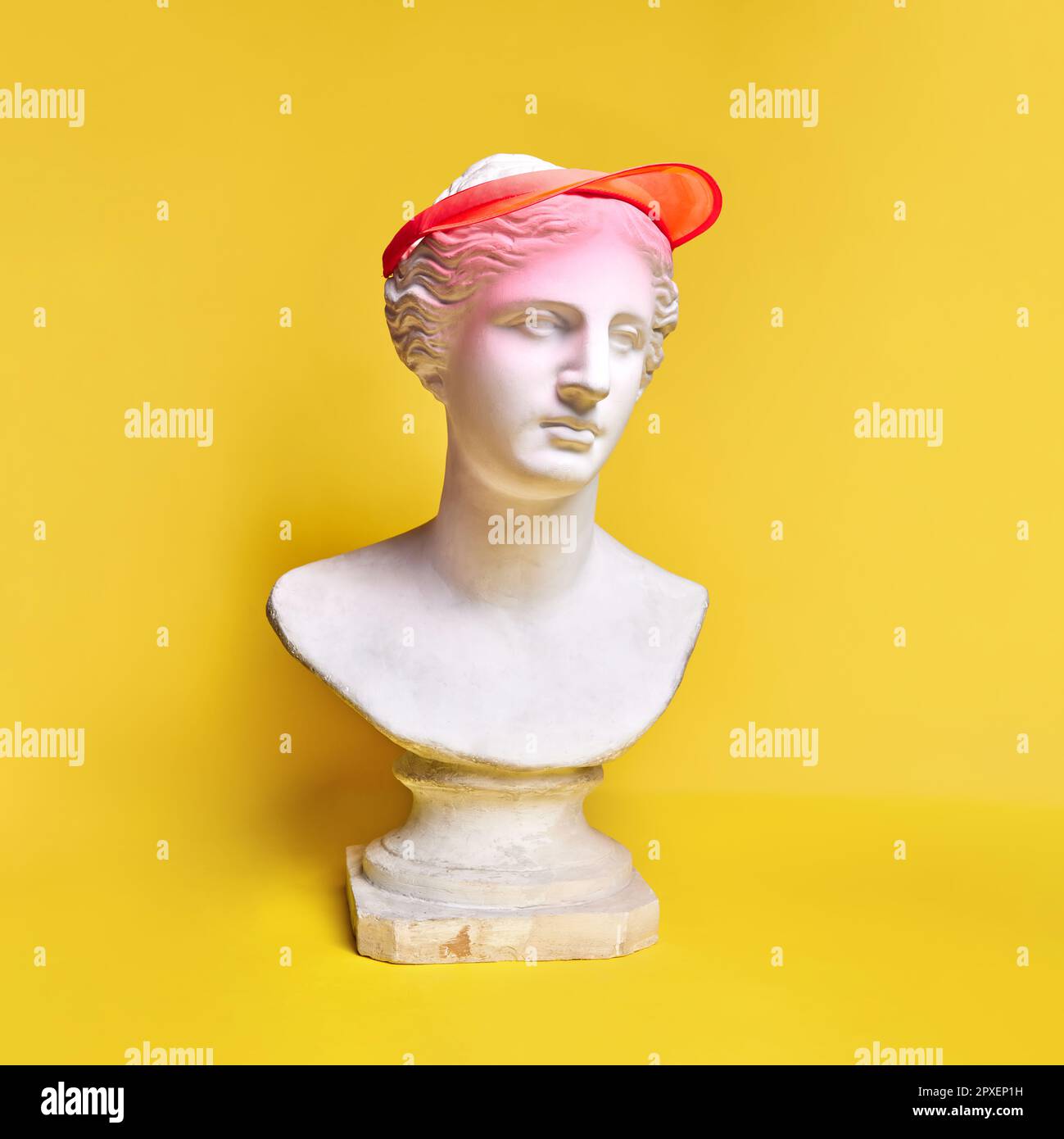 Antique statue bust wearing stylish cap against yellow background ...