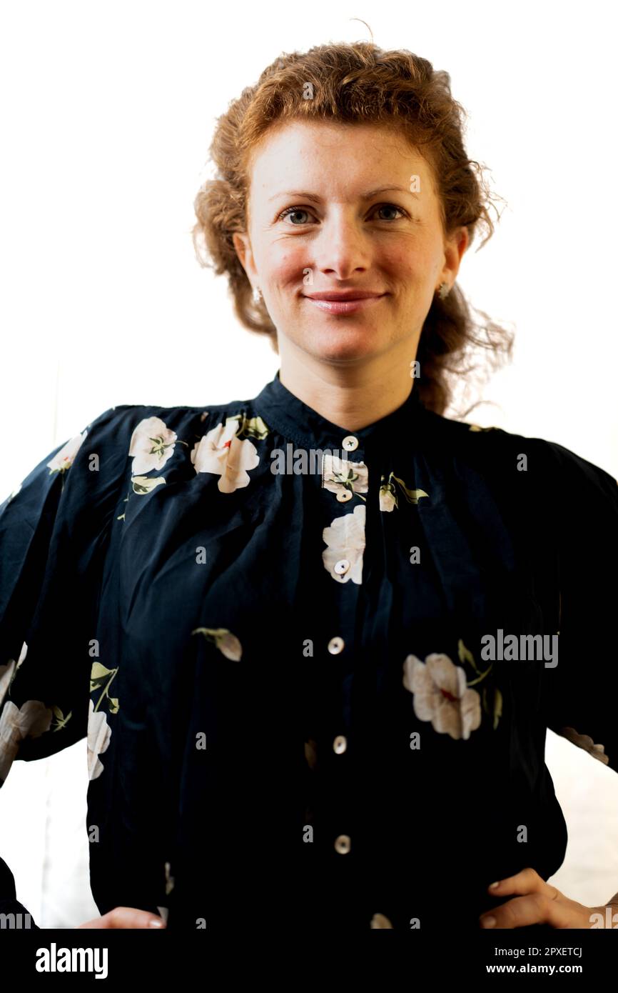 A vertical of a ginger model posing, dressed in an elegant blue shirt ...
