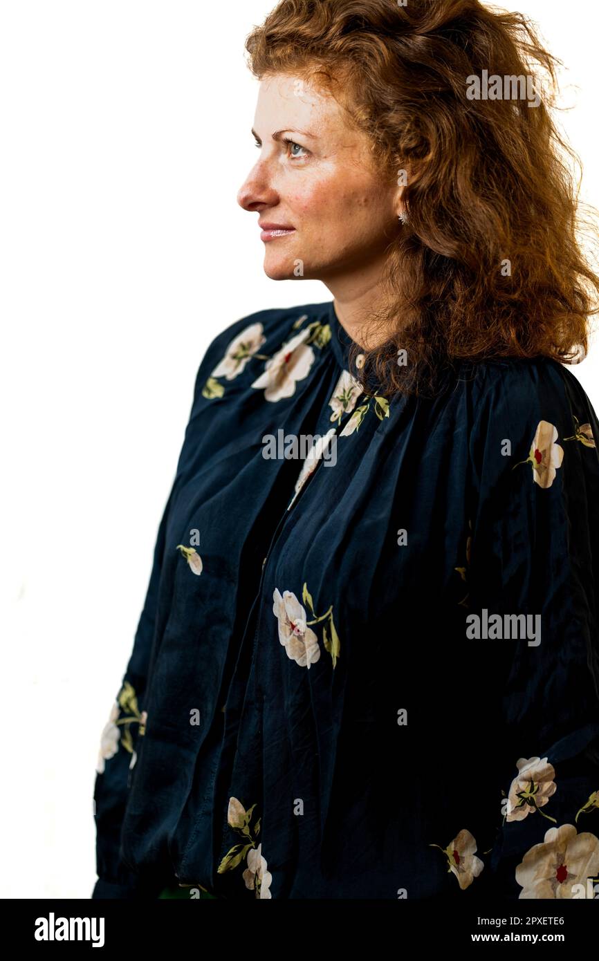 A vertical of a ginger model posing, dressed in an elegant blue shirt ...