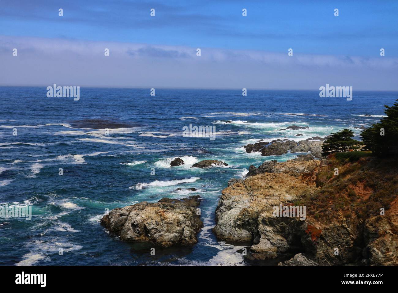 A stunning landscape featuring an ocean shoreline with rocky formations ...