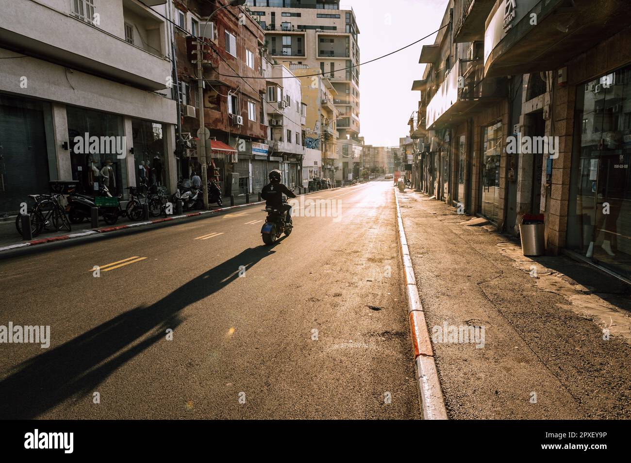 A person riding a motorcycle down a quiet Tel Aviv, Israel street Stock ...