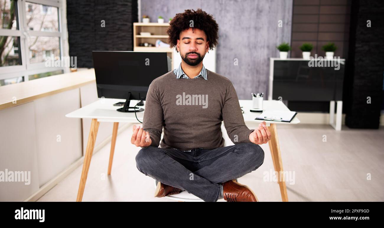 African American Male Meditation In Office Near Computer Stock Photo ...