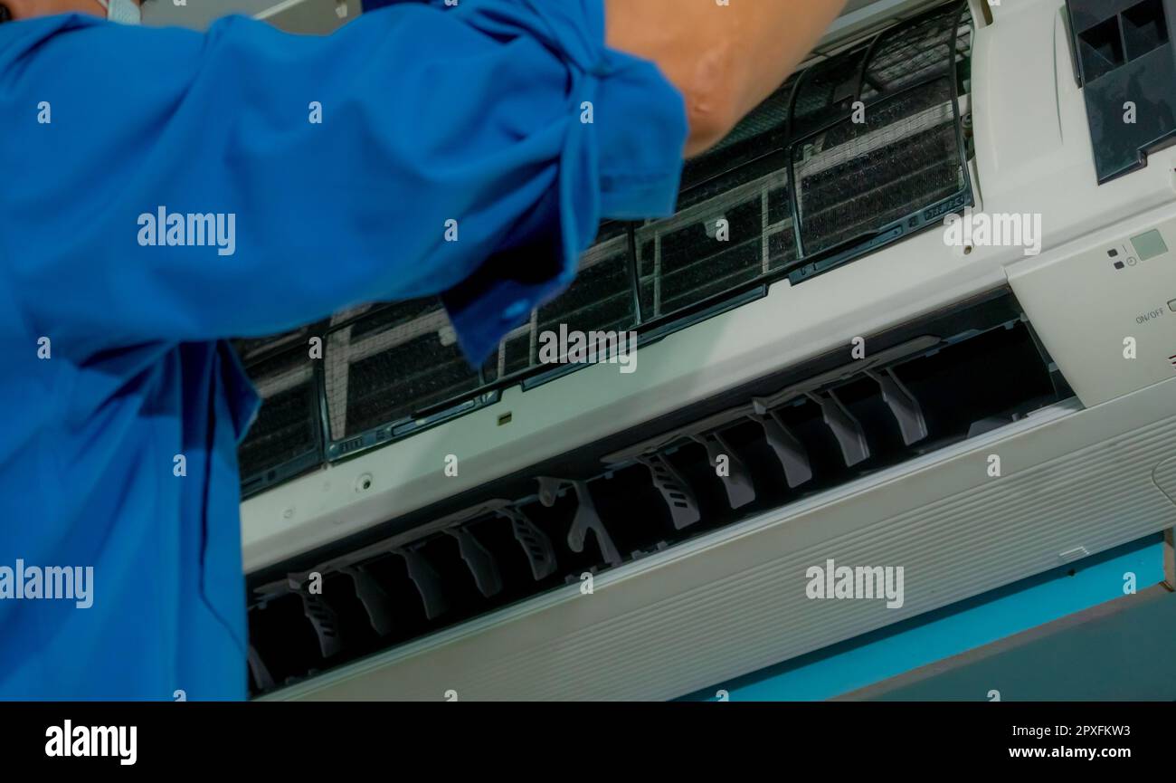 Air conditioner repair by a man. Technician clean air conditioner that ...