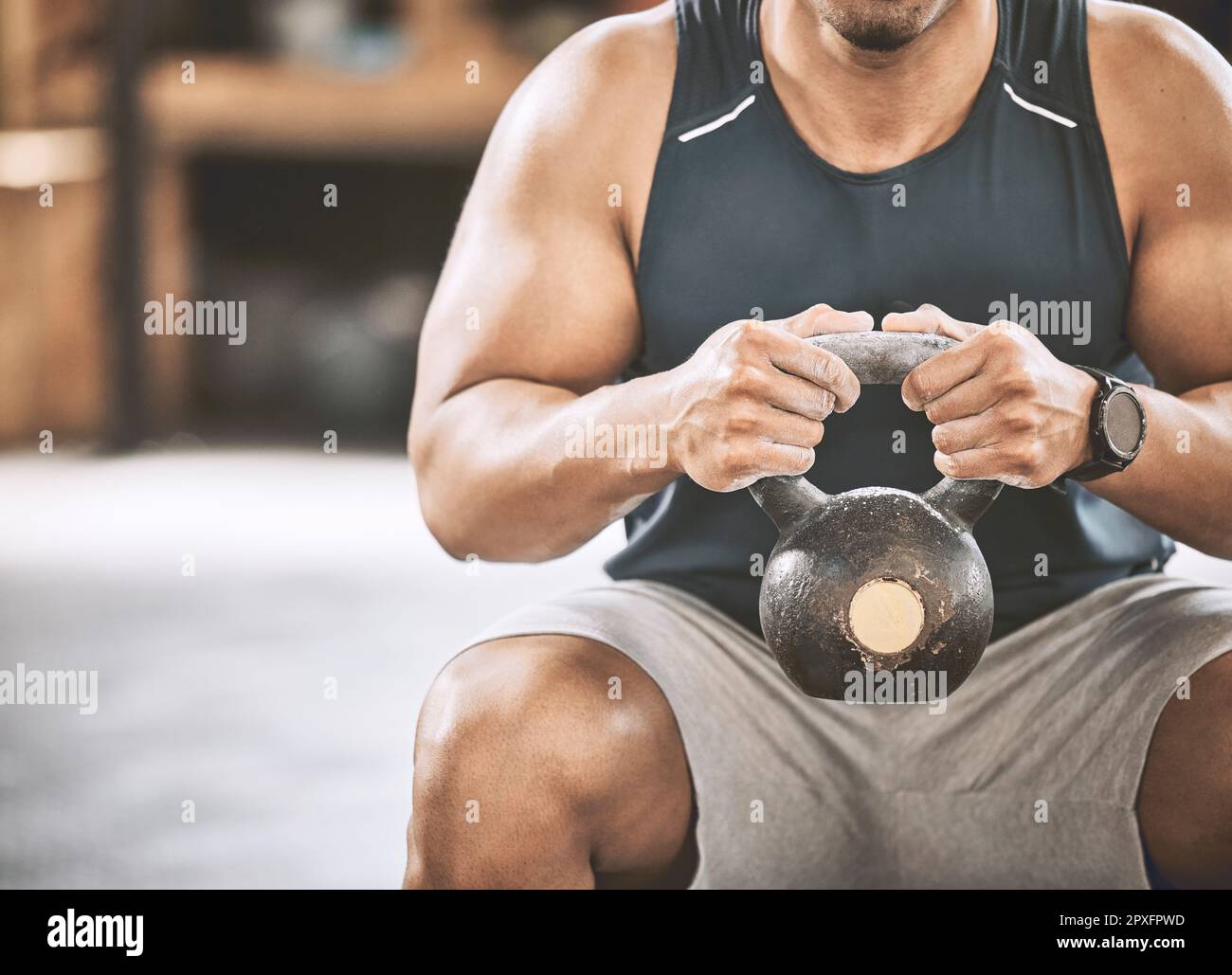 Trainer holding heavy kettlebell in the gym cropped. Hands of a ...