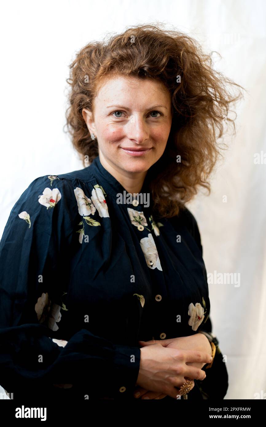 A vertical of a ginger model posing, dressed in an elegant blue shirt ...
