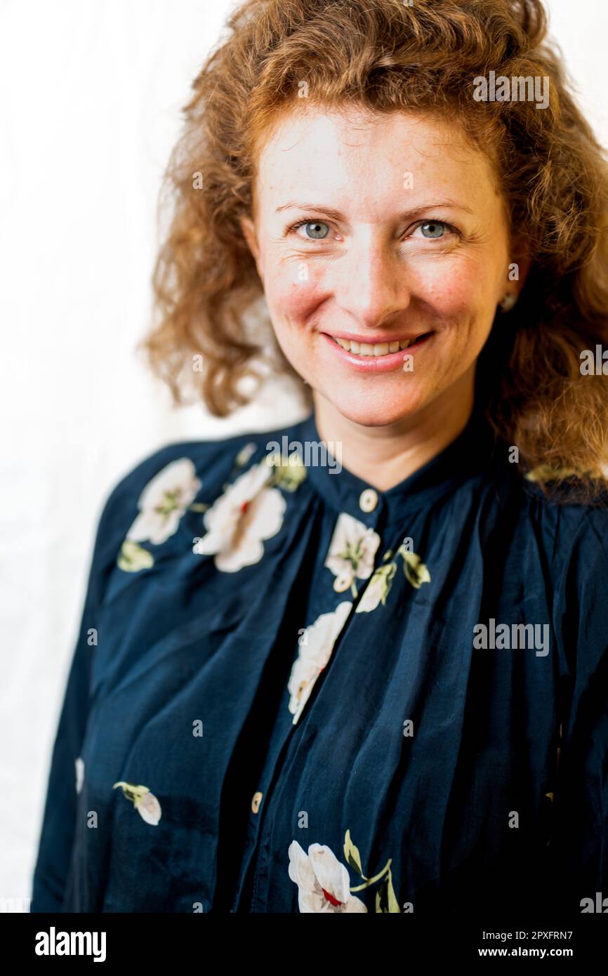 A vertical of a ginger model posing, dressed in an elegant blue shirt ...