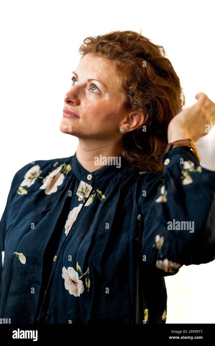 A vertical of a ginger model posing, dressed in an elegant blue shirt ...