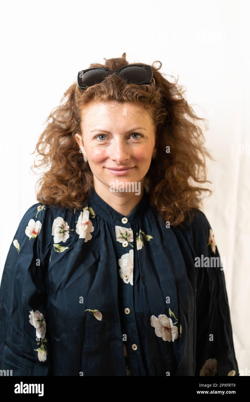 A vertical of a ginger model posing, dressed in an elegant blue shirt ...