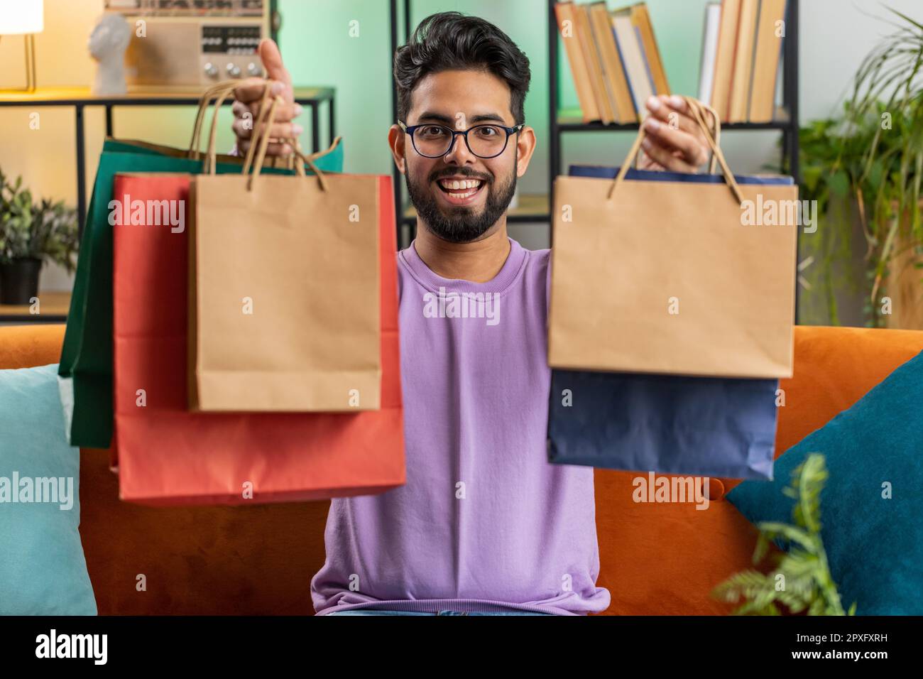 Young indian man happy shopaholic consumer came back home after ...
