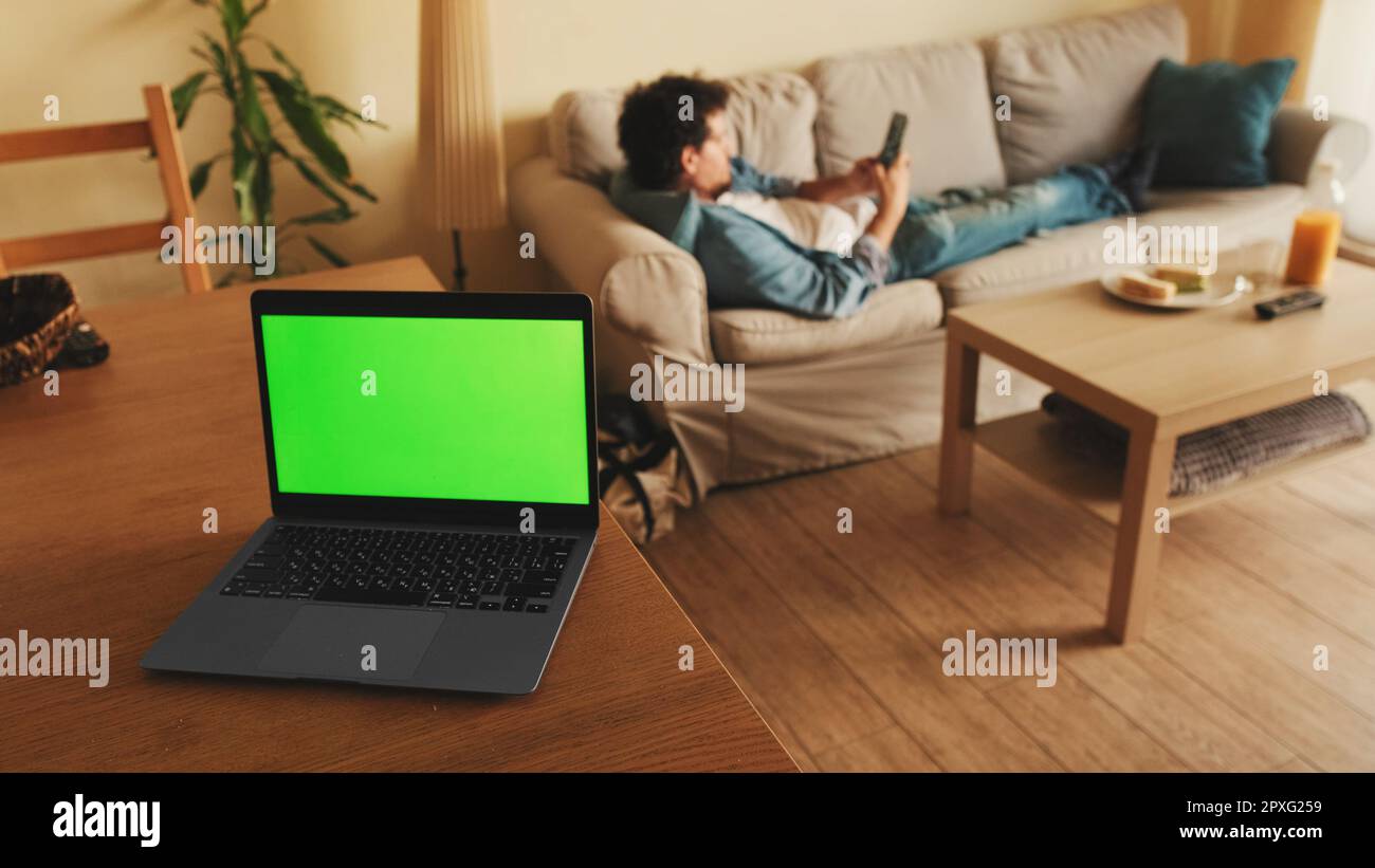 Laptop with green chromo key on the screen, mock-up screen, stands on ...