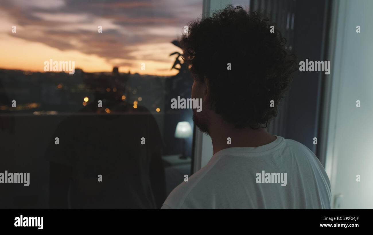 Close-up of young man looking out the window at the sunset Stock Photo ...