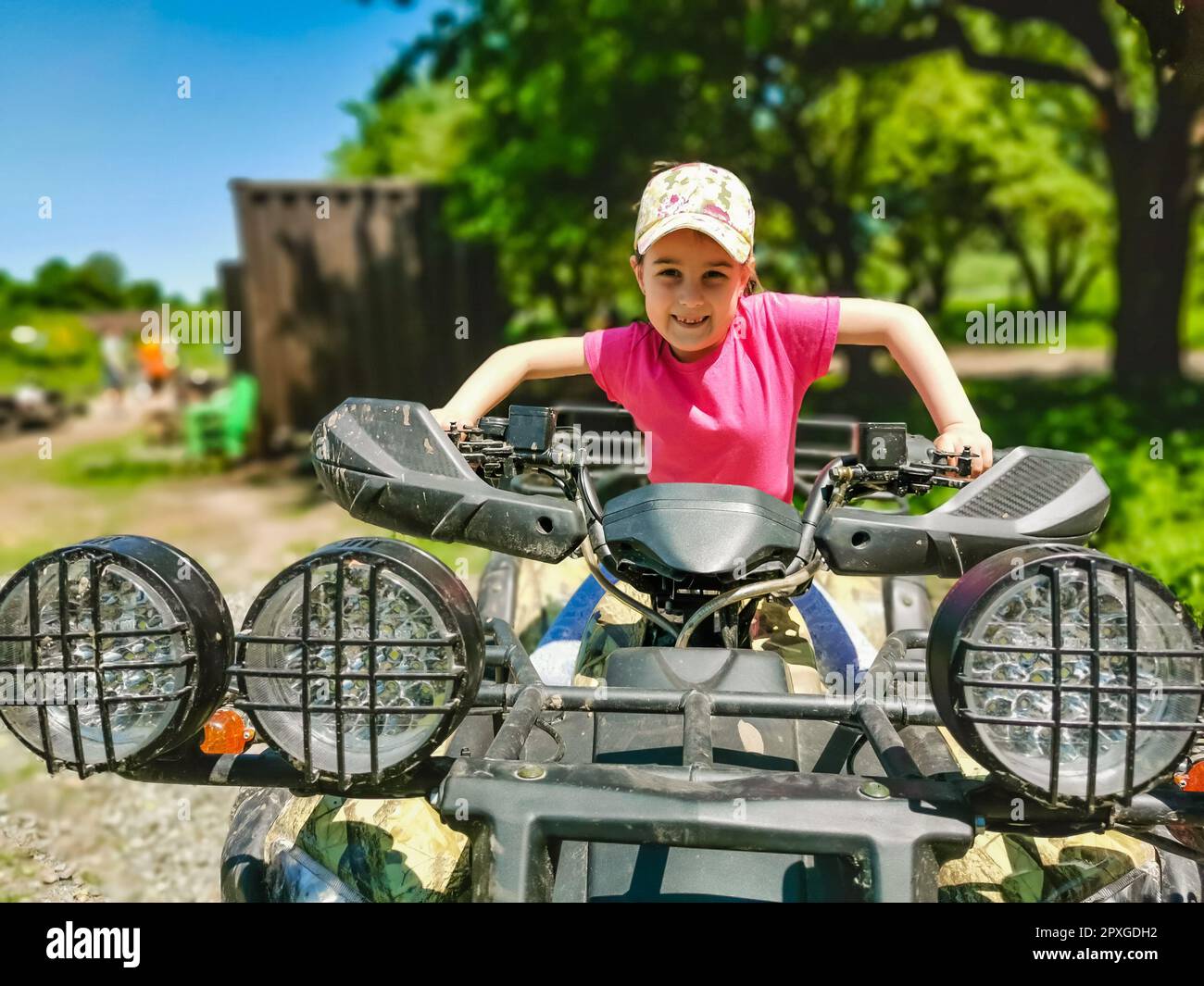 Little girl riding ATV quad bike in race track Stock Photo - Alamy