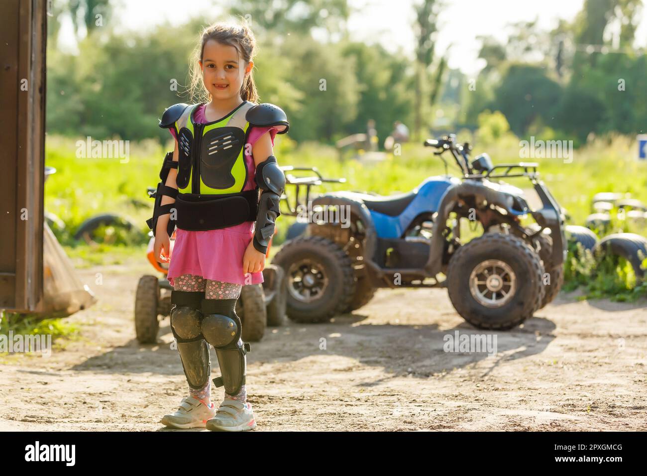 Little girl riding ATV quad bike in race track Stock Photo - Alamy