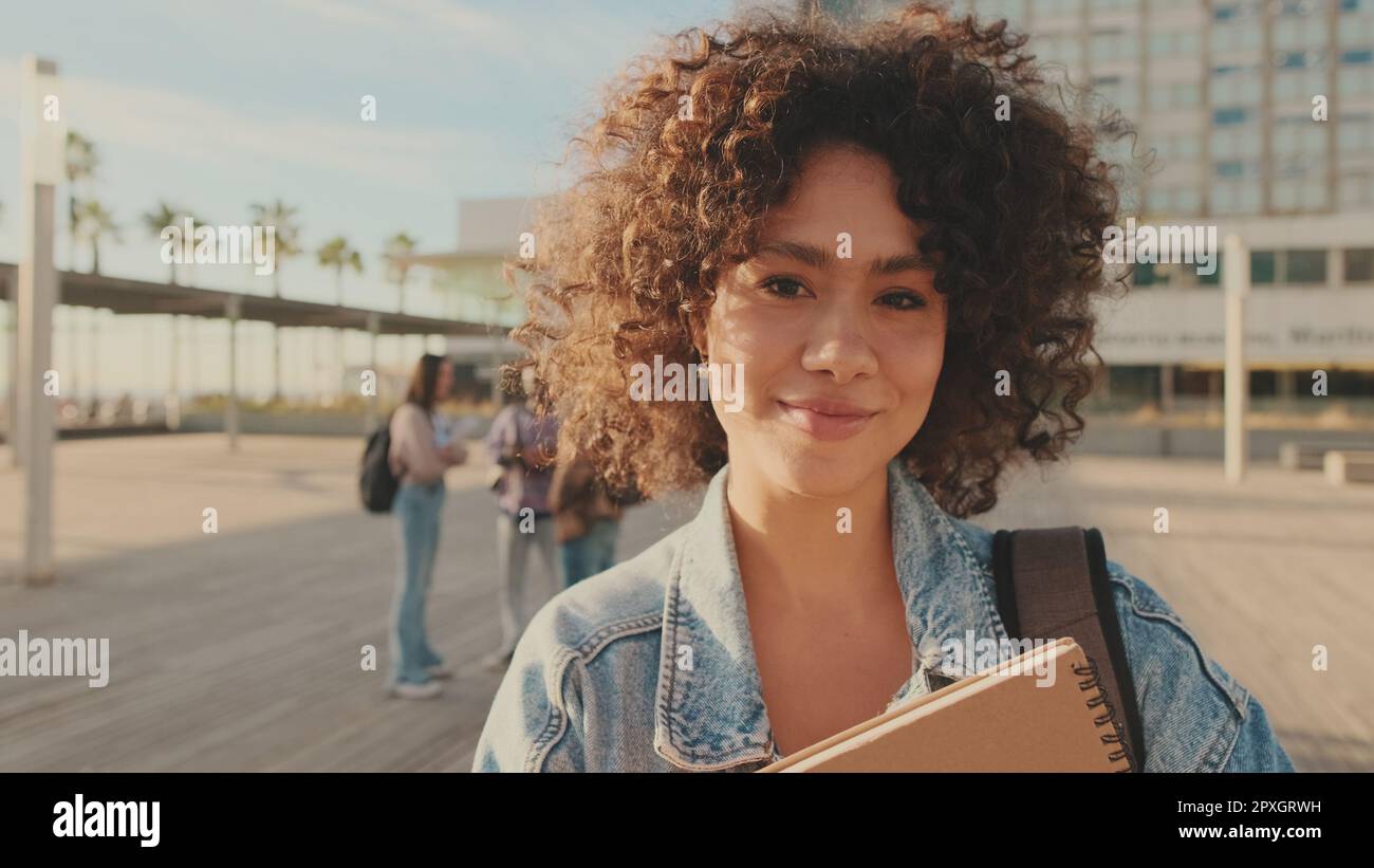 Girl is smiling while looking at the camera. Student with notebooks in ...