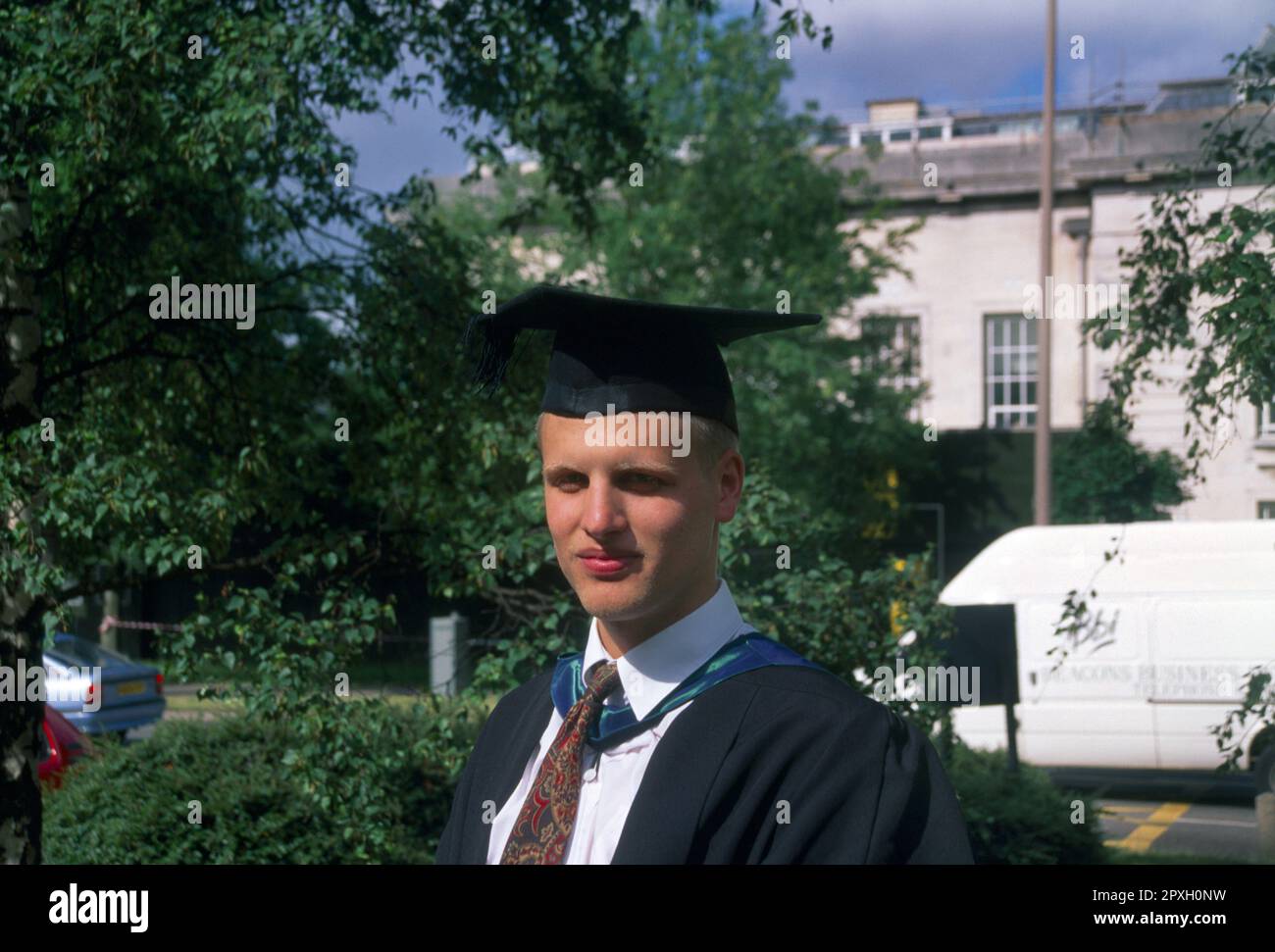 Portrait of Young Man on Graduation Day Wearing Mortar Board and Gown ...