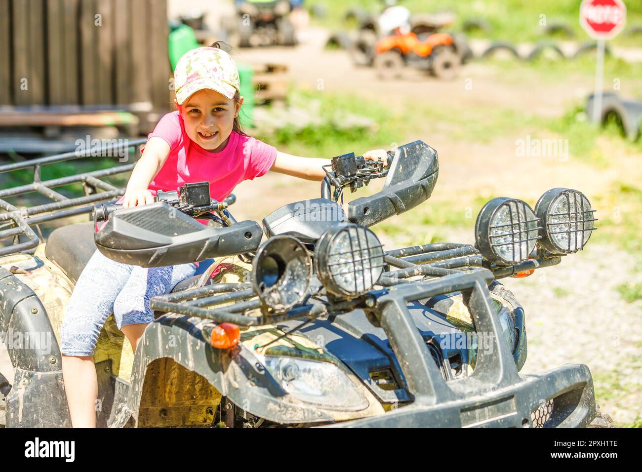 Little girl riding ATV quad bike in race track Stock Photo - Alamy