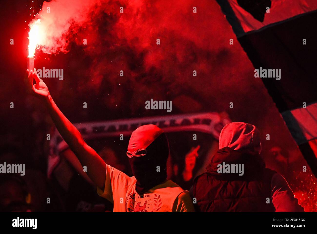 A PSG supporter holds a smoke bomb in his hands during the French ...
