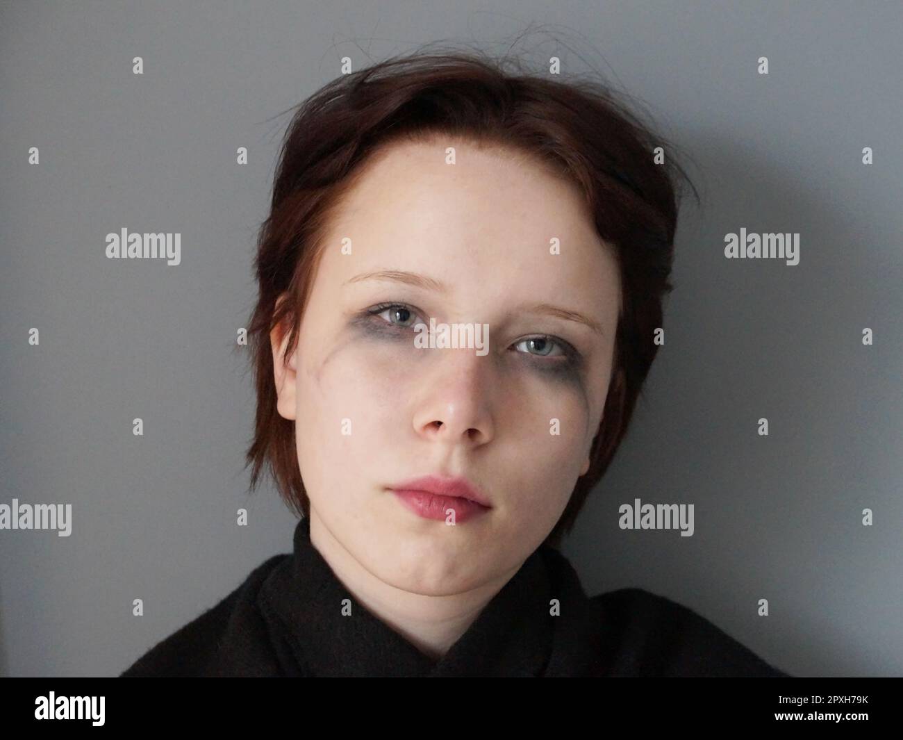 portrait of a sad teenage girl with short brown hair and tearful eyes ...