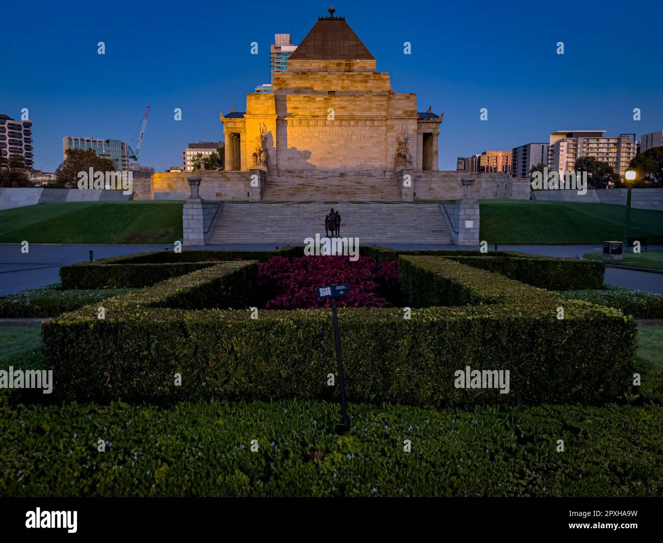 An illuminated war memorial building in Melbourne, Australia at night with a bright glow ...