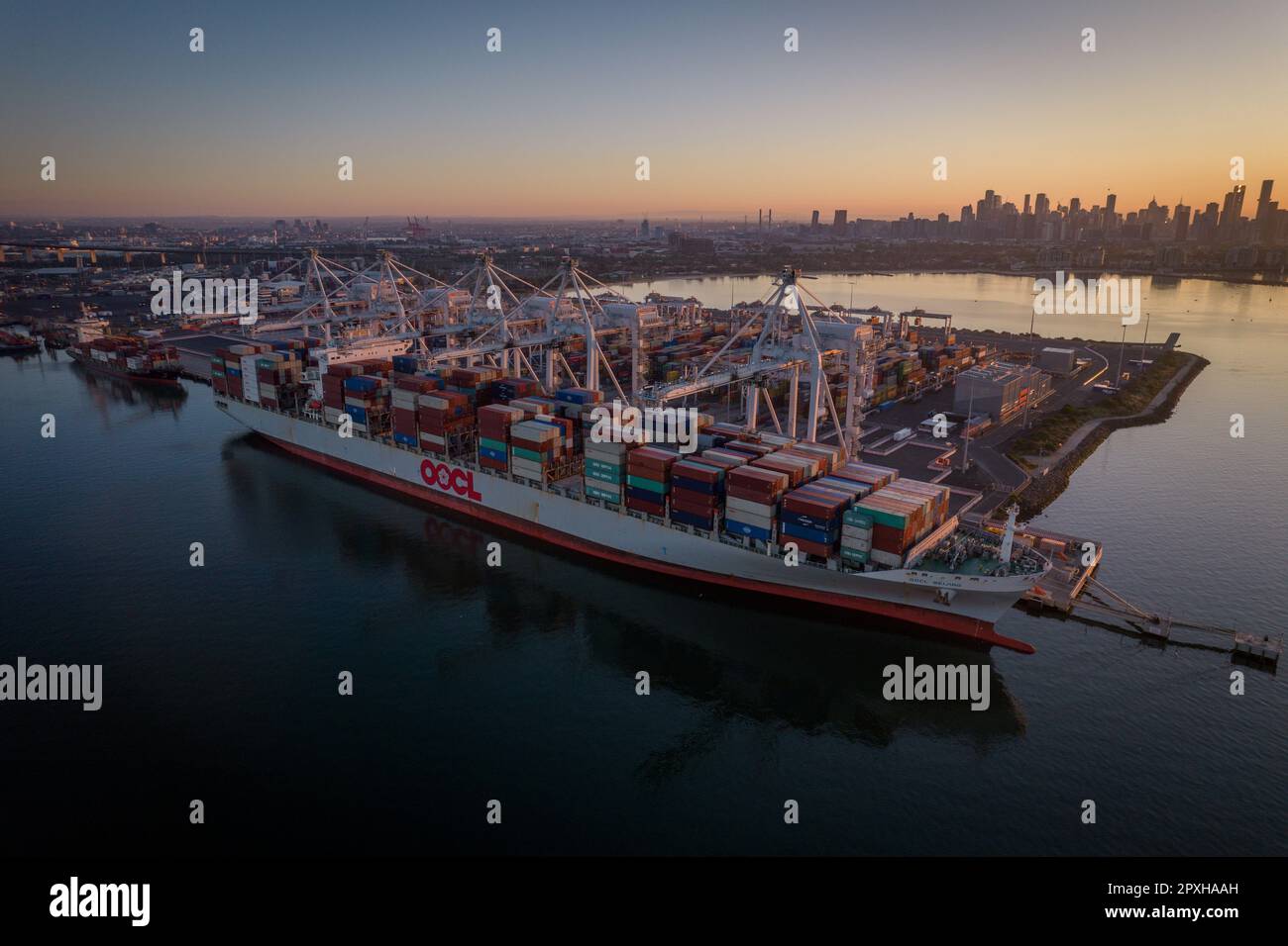 Aerial view of a large cargo container ship OOCL docked at a busy ...