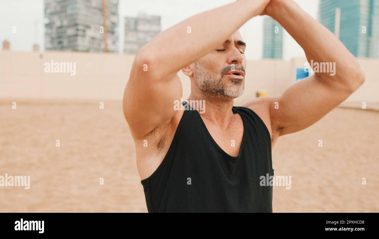 Close-up, middle-aged man doing relaxing breathing exercises standing ...