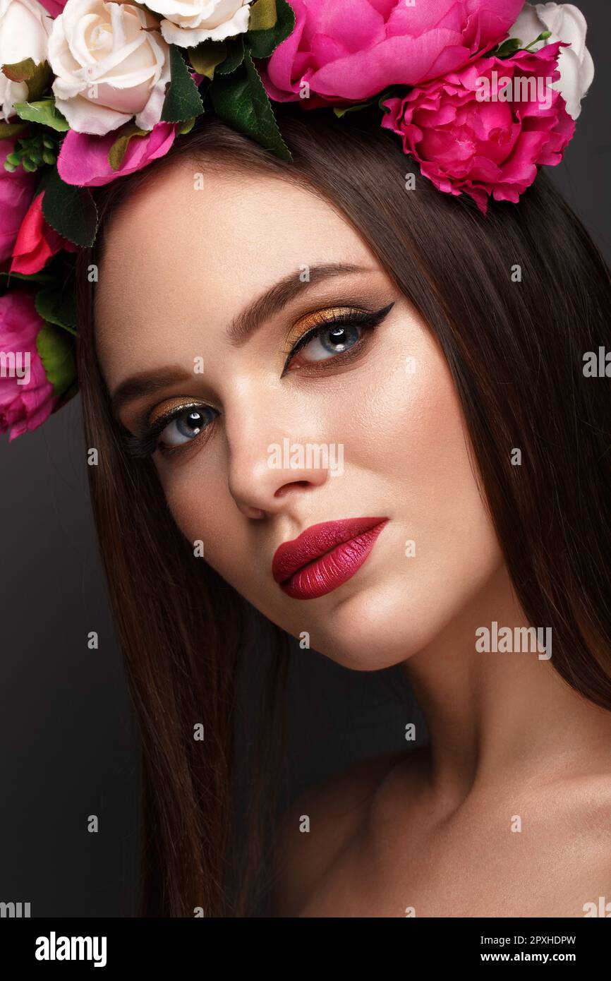 Beautiful girl with bright make up and flowers on her head. Beauty face ...