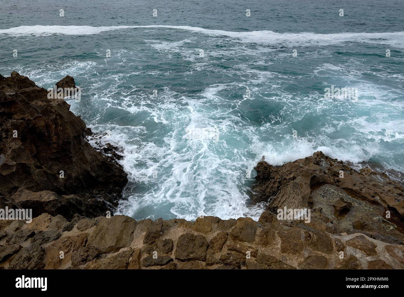Waves breaking on the shore on a pebble road. water foam, wild waters ...